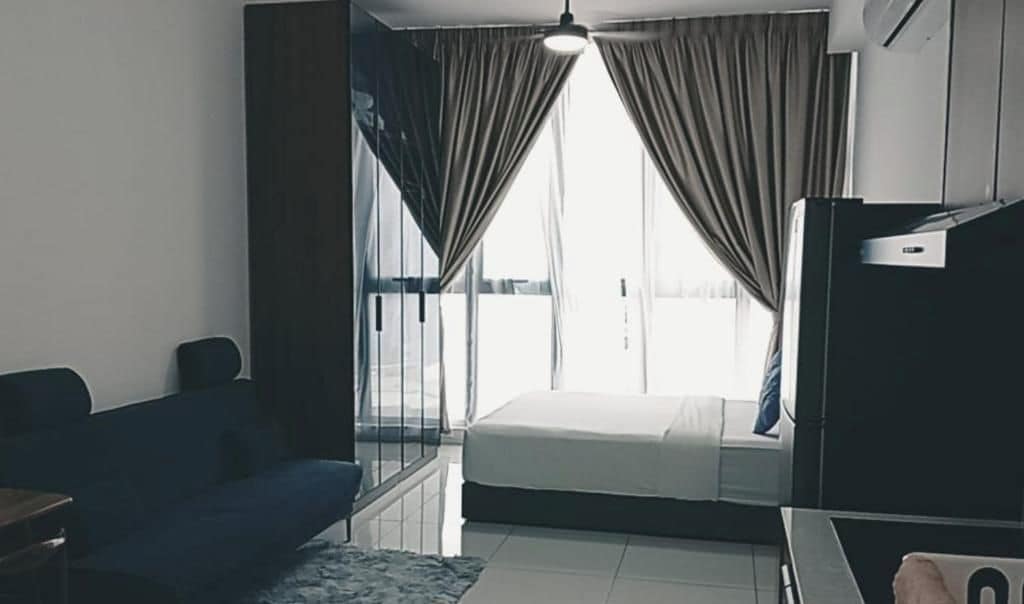 Quarto de hotel moderno com cama, sofá, escrivaninha e janela com cortinas.