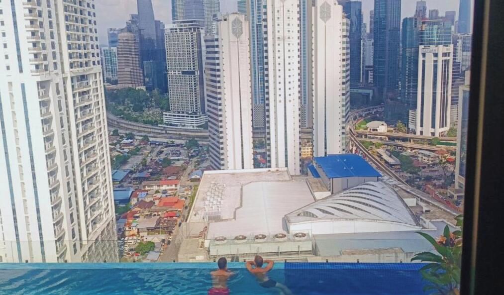 Um edifício alto com vista para o horizonte urbano, incluindo um estádio e outras construções.