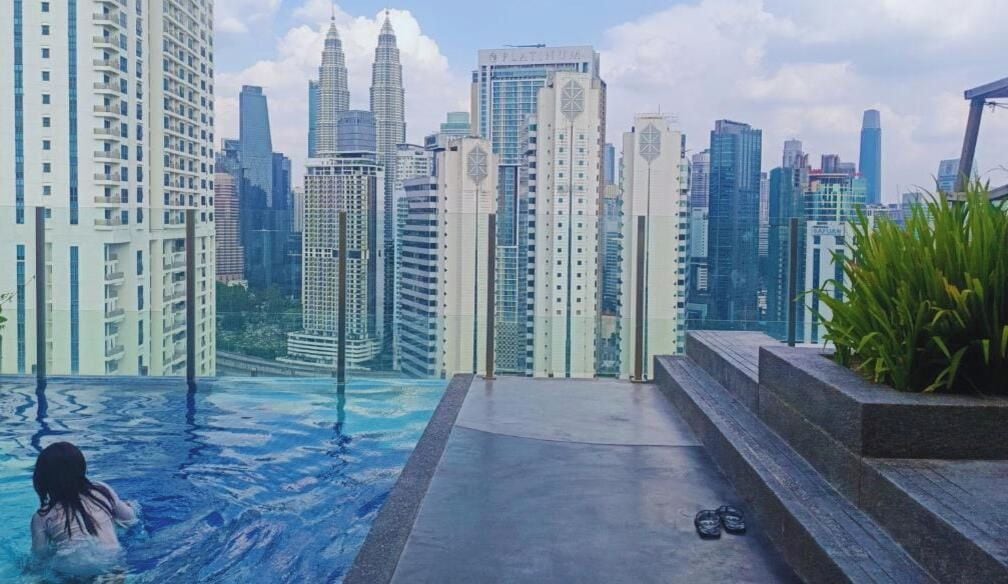 Área da piscina com vista para o horizonte urbano, incluindo edifícios altos e uma torre imponente.