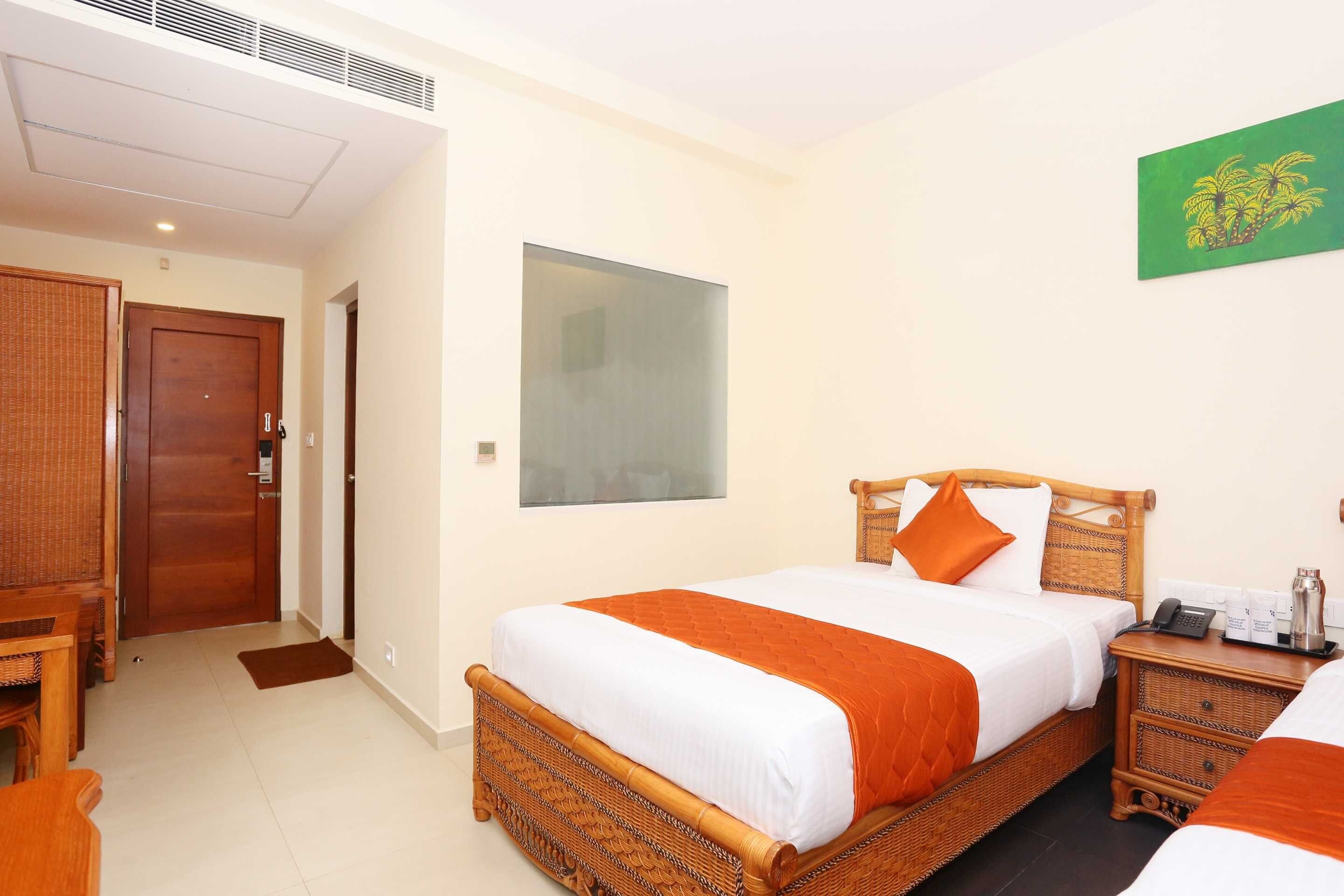 Quarto de hotel com cama, mesa de cabeceira e uma obra de arte na parede.