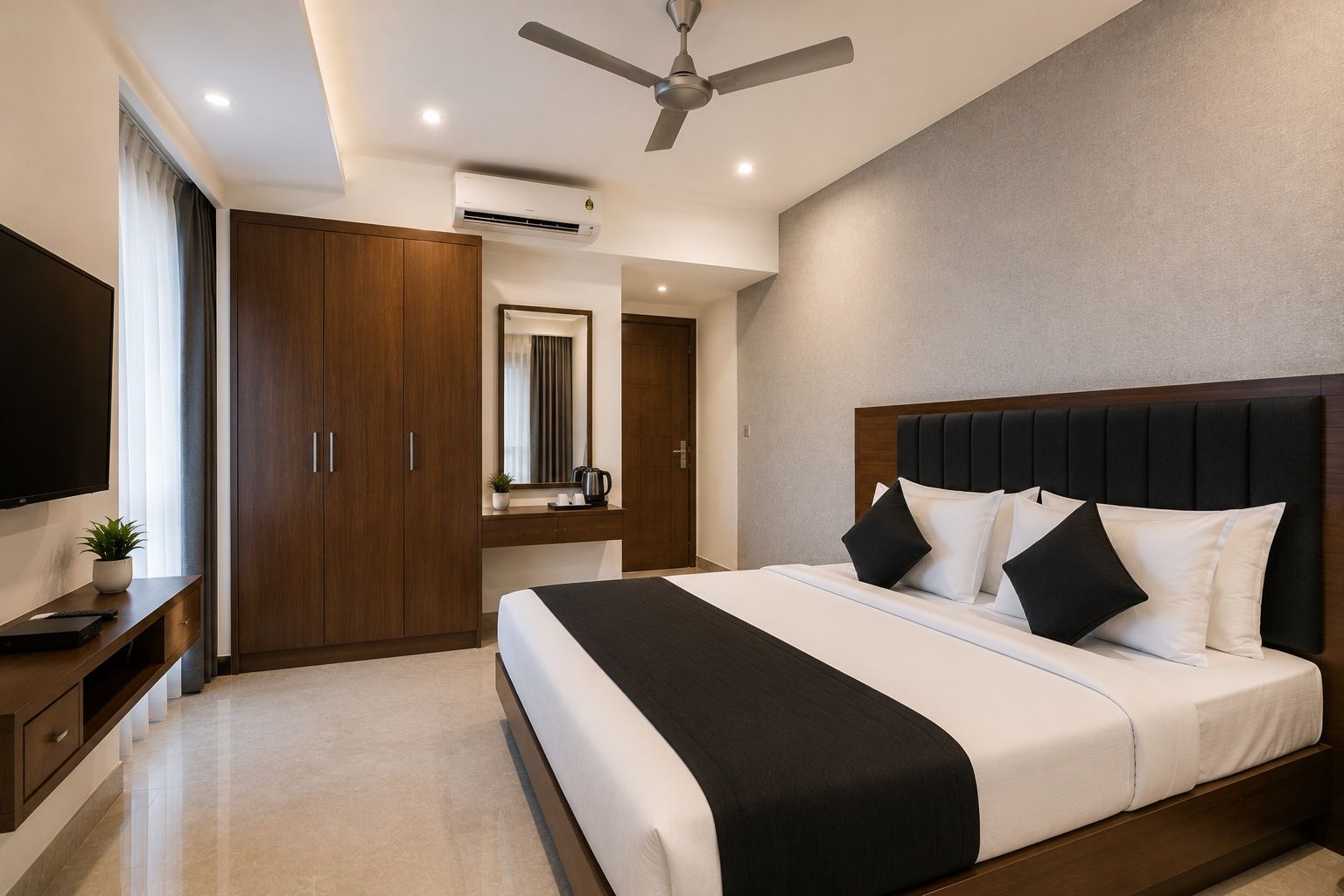 Quarto de hotel moderno com cama grande, guarda-roupa, TV de tela plana e ventoinha de teto.