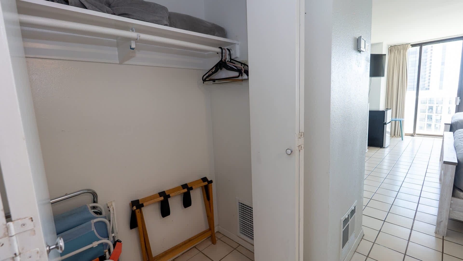 Quarto de hotel com cama, guarda-roupa, radiador, aquecedor e vista para o exterior.