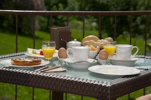 Mesa de café da manhã com pratos, xícaras e diversos alimentos.