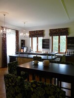 Espaço de refeições com mesa, cadeiras e um lustre.