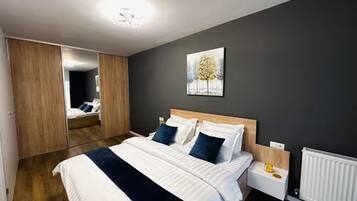 Quarto com cama, mesa de cabeceira e radiador.