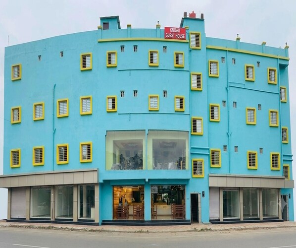 Um edifício de vários andares com uma placa que diz 'Knight Guest House'.