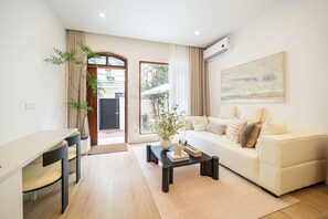 Uma sala de estar moderna com sofá, mesa de centro e um quadro na parede.