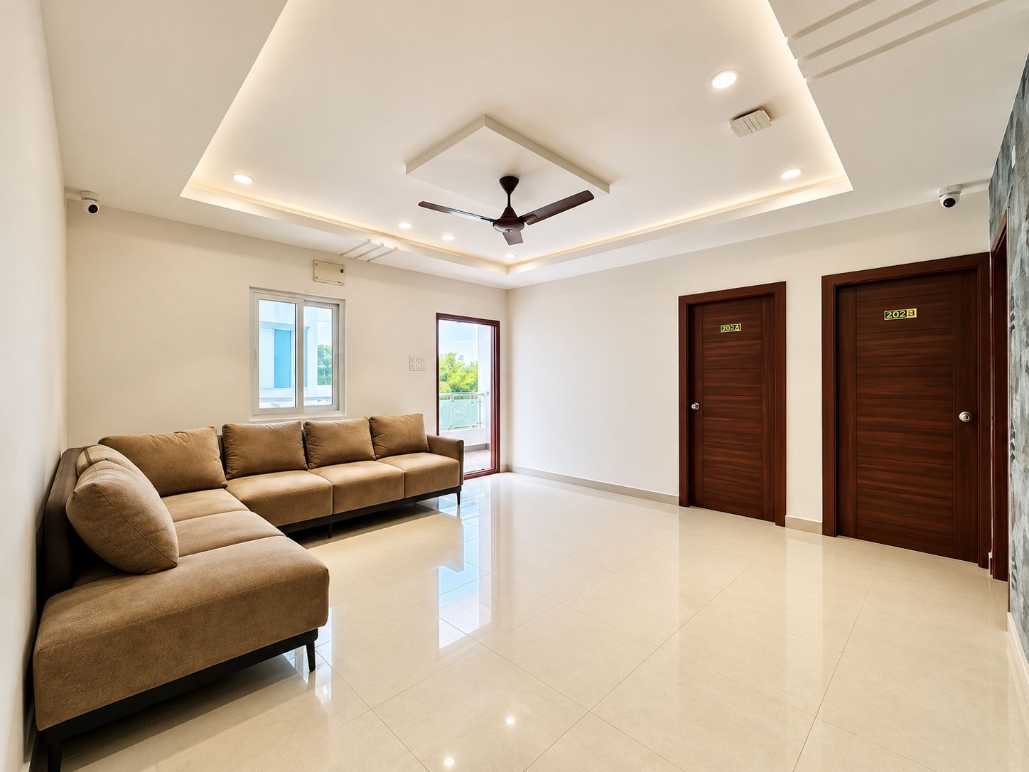 Quarto espaçoso com sofá, duas portas e ventilador de teto.