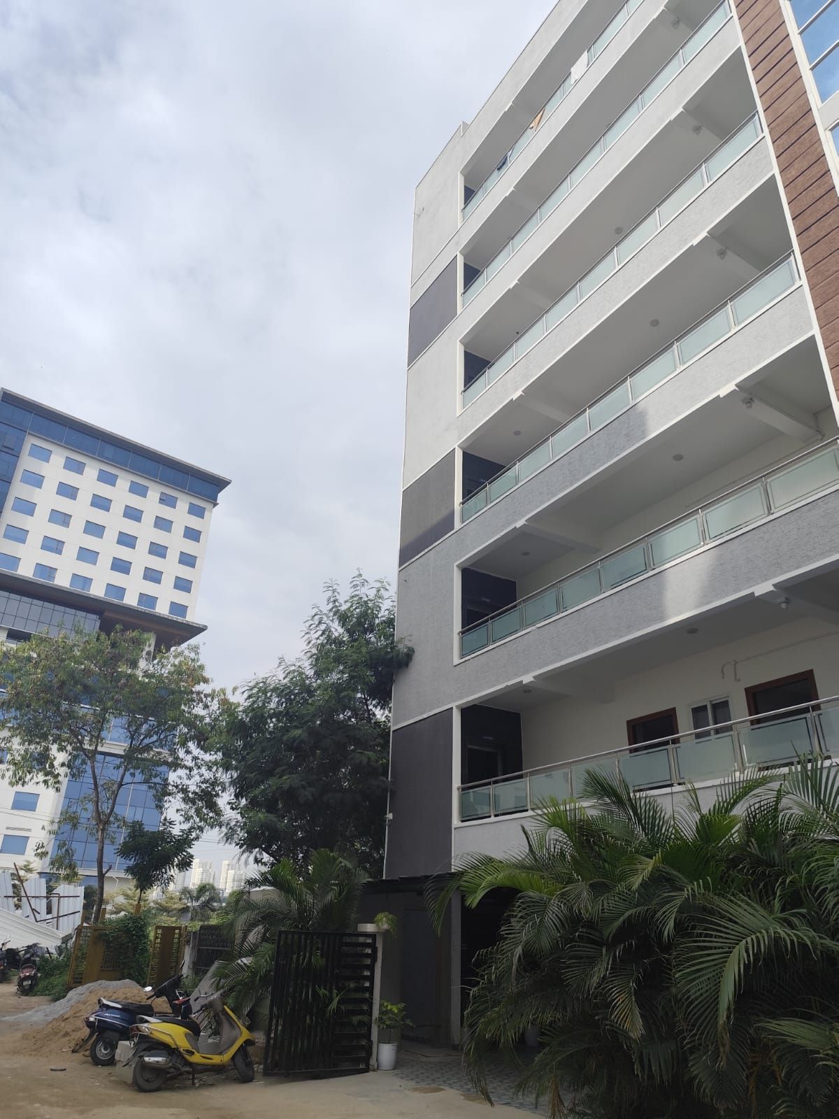 Um edifício de vários andares com sacadas e entrada protegida por portão.