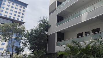 Um edifício de vários andares com sacadas e entrada protegida por portão.
