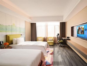Quarto de hotel com duas camas, uma escrivaninha, uma cadeira, uma televisão e uma janela grande.