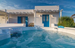 Um edifício moderno com piscina, porta azul e fachada branca.