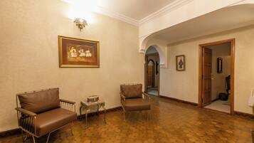 Quarto com duas poltronas de couro, uma mesinha e um quadro na parede.