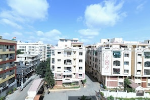 Um edifício residencial com vários andares, varandas, um pátio central e uma bandeira.