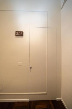 Porta fechada com placa indicando o quarto 303.