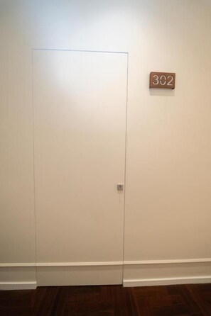 Porta fechada com uma placa de identificação '302' na parede.