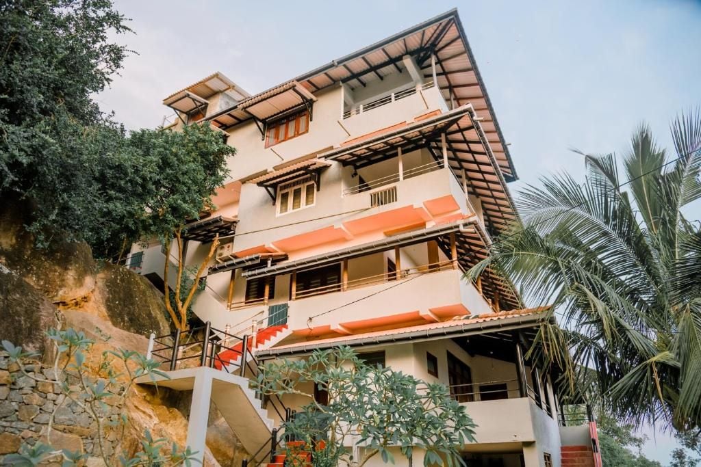 Um edifício com várias andares, varandas e uma escadaria que leva à entrada.