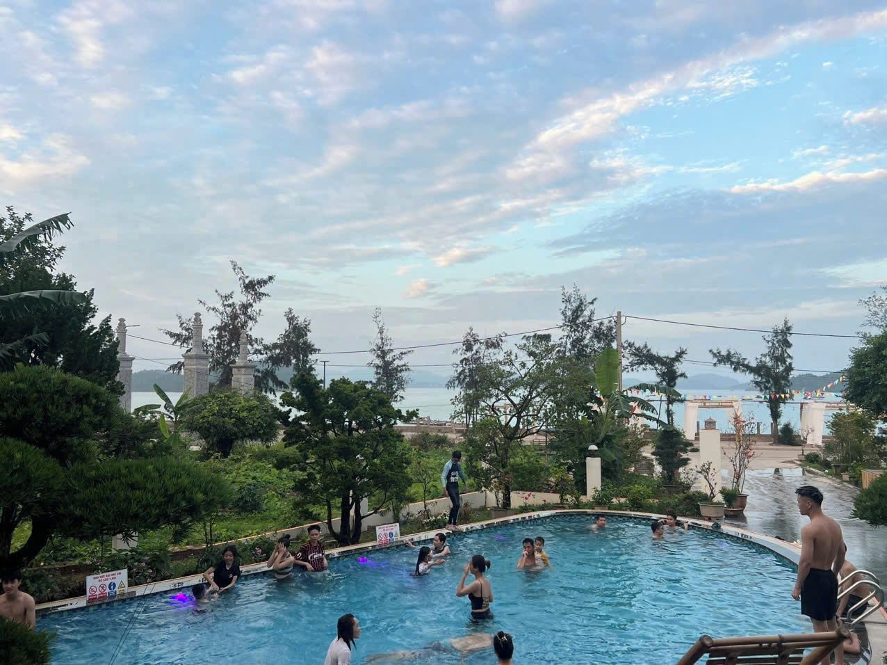 Piscina cercada por árvores e vista para o horizonte da cidade.