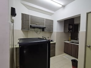 Uma cozinha compacta com geladeira, pia e armários.
