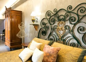 Quarto com cama, guarda-roupa de madeira e luminária na parede.