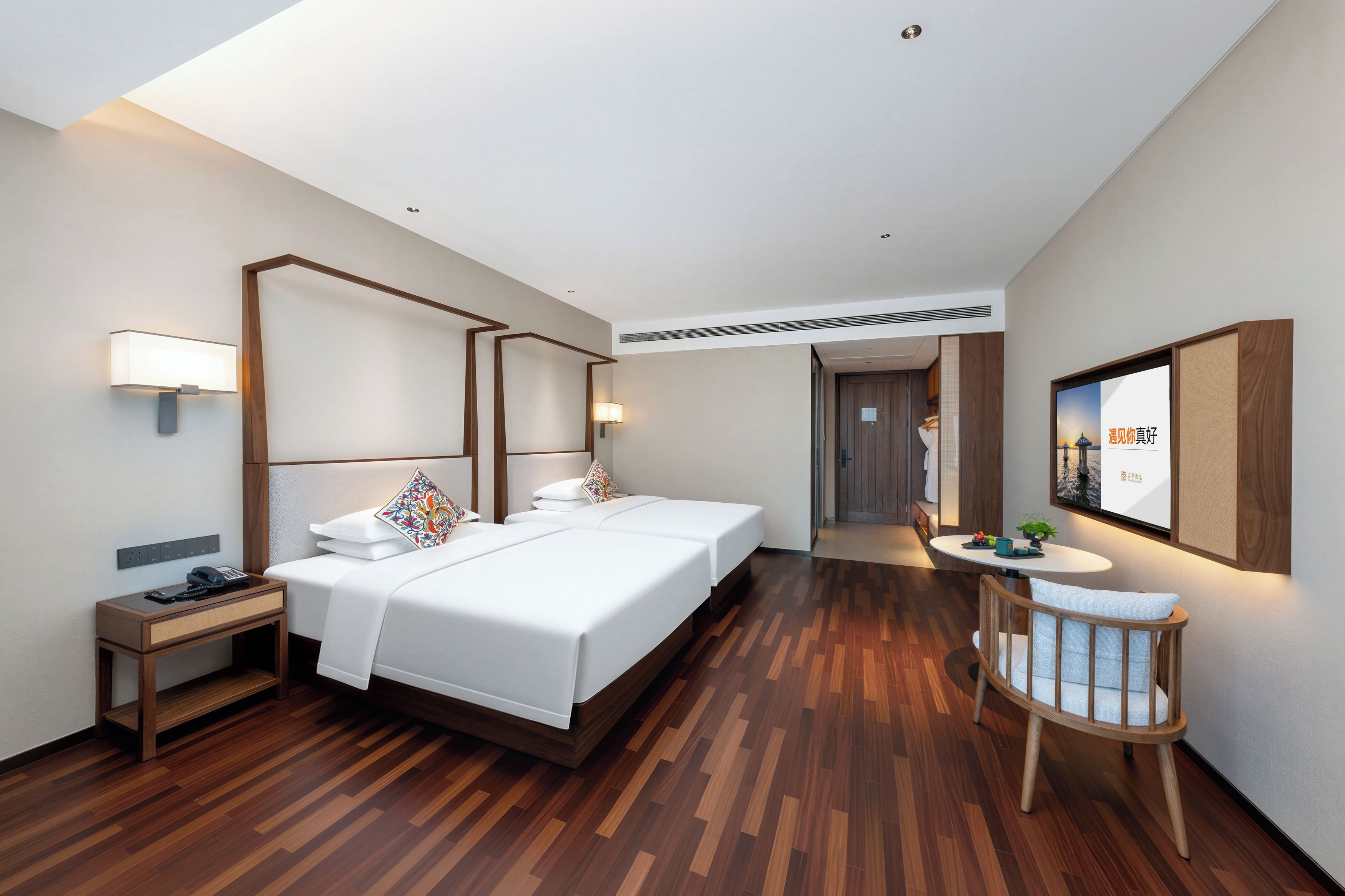 Quarto de hotel com uma cama grande, mesas de cabeceira, escrivaninha e uma cadeira.