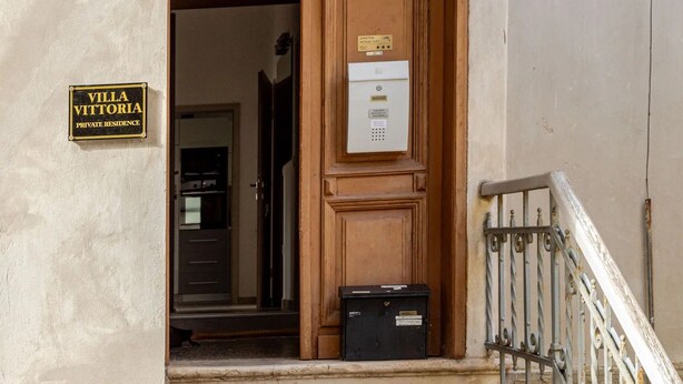 Degraus de pedra levam a uma porta de madeira com uma placa indicando propriedade privada.