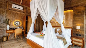 Quarto com cama de dossel, escrivaninha com cadeira, ar-condicionado fixado na parede e cesta de fibra.