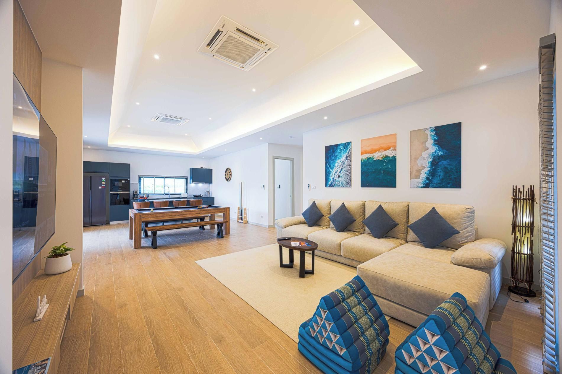 Uma sala de estar moderna com sofá, mesa de centro e mesa de bilhar.