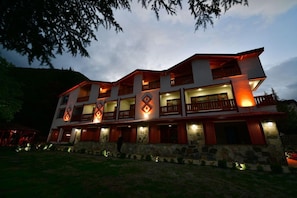 Um hotel com vários andares, varandas e fachada de pedra.