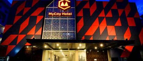 Um hotel com fachada geométrica marcante e placa visível.