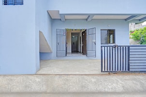 Uma entrada de edifício com uma entrada gradeada, porta visível e pequena janela com grades.