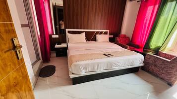 Quarto com cama, mesa de cabeceira, espelho e porta.
