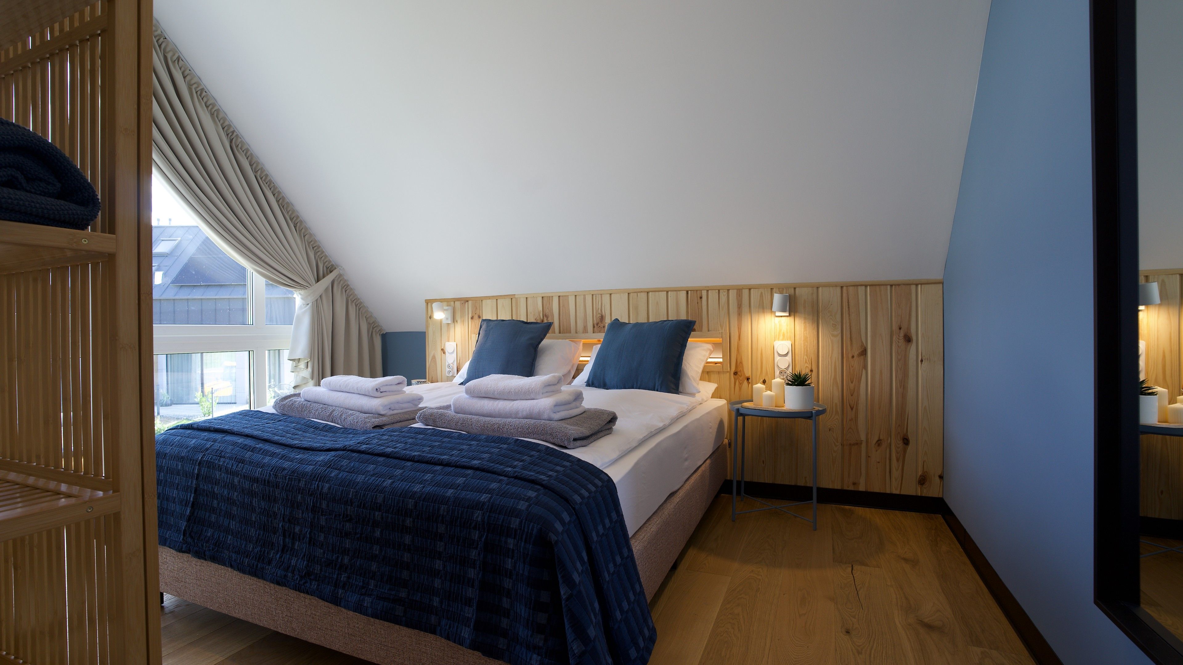 Quarto com cama, mesas de cabeceira e uma janela.