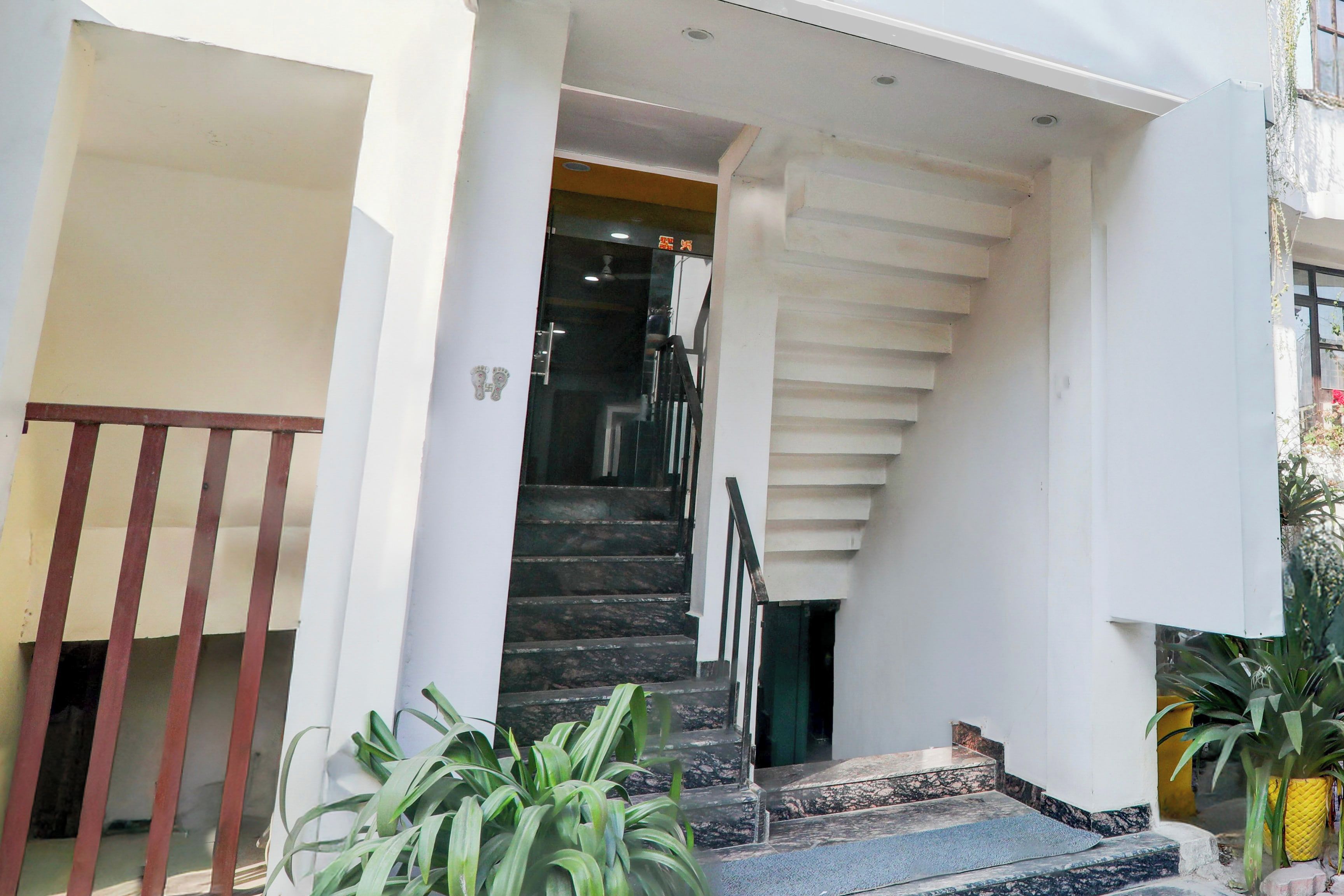Escadaria que leva a um espaço interior, com corrimão e uma porta no topo.