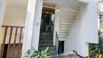 Escadaria que leva a um espaço interior, com corrimão e uma porta no topo.