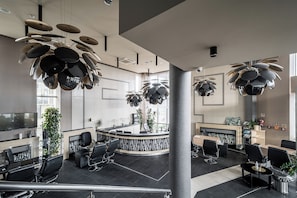 Decoração moderna com balcão de atendimento, área de estar e luminárias de design exclusivo.
