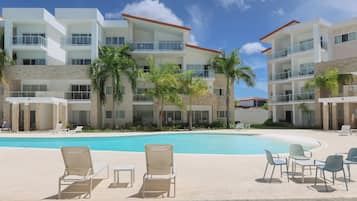 Um resort com piscina, espreguiçadeiras e palmeiras.