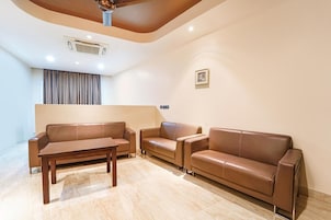 Uma sala de estar moderna com um sofá de couro marrom, uma mesa de centro de madeira e um ventilador de teto.