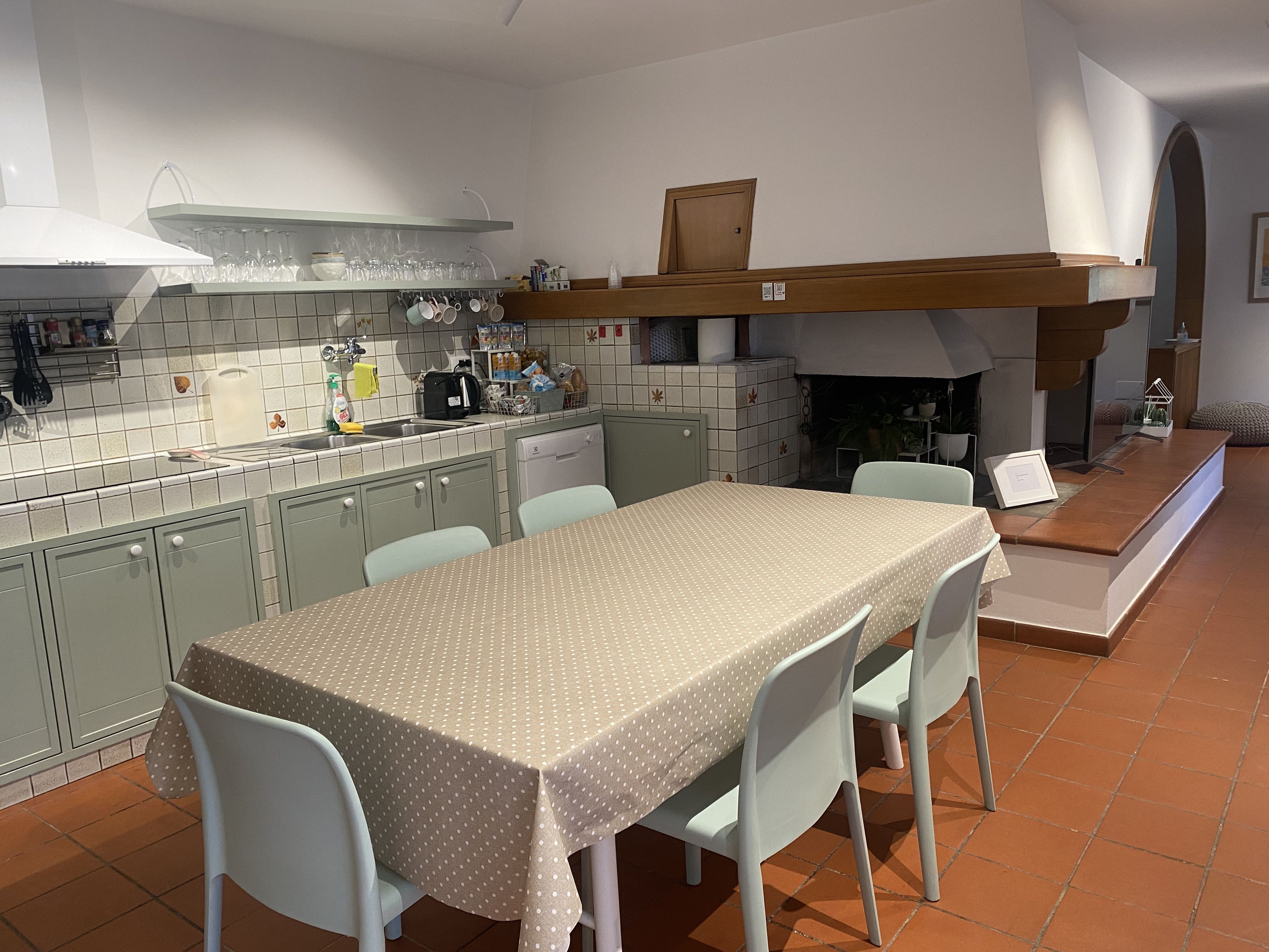 Uma cozinha com mesa, cadeiras e painel de azulejos.