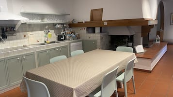 Uma cozinha com mesa, cadeiras e painel de azulejos.