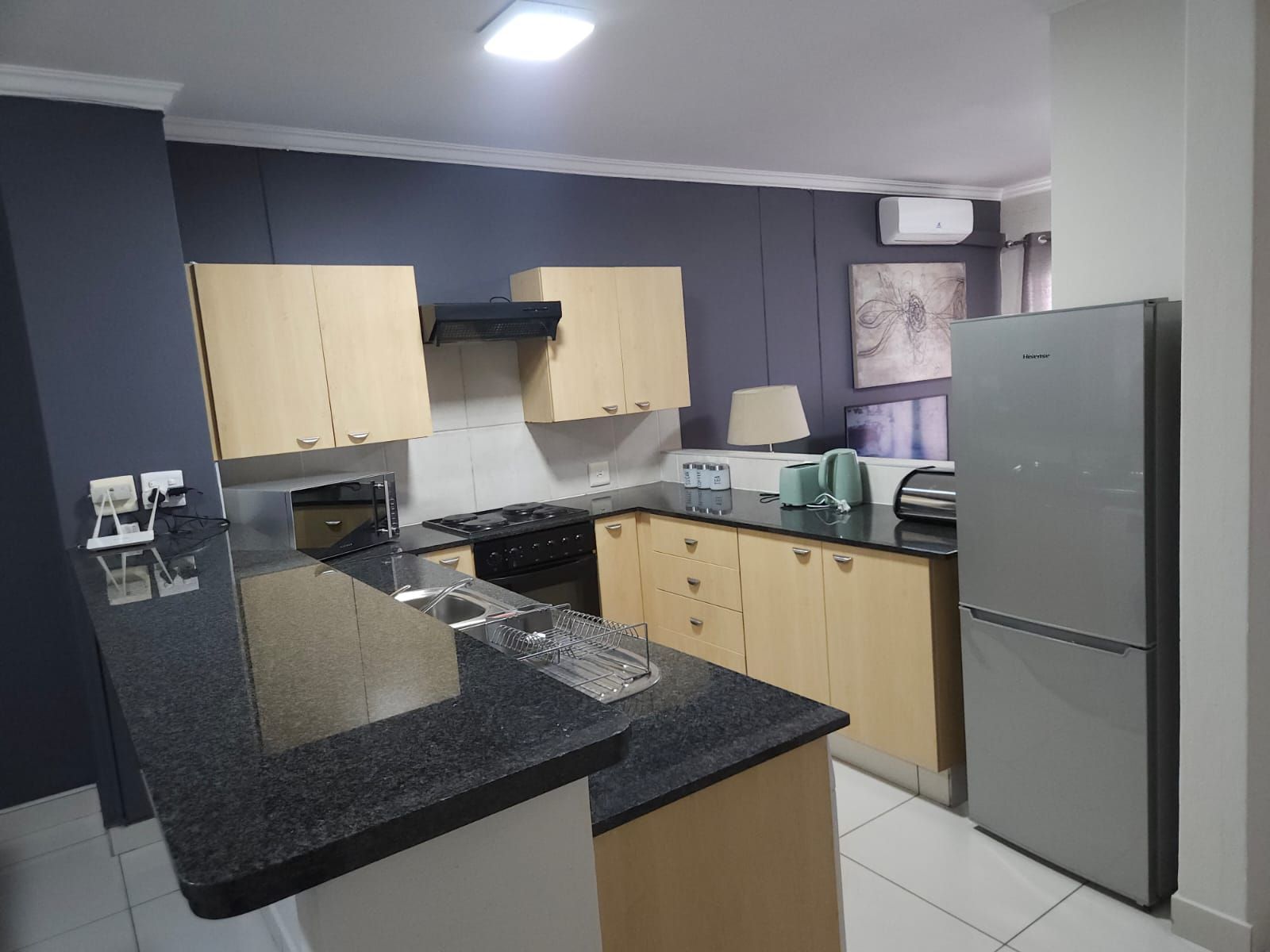 Cozinha moderna com uma ilha central, fogão e geladeira.
