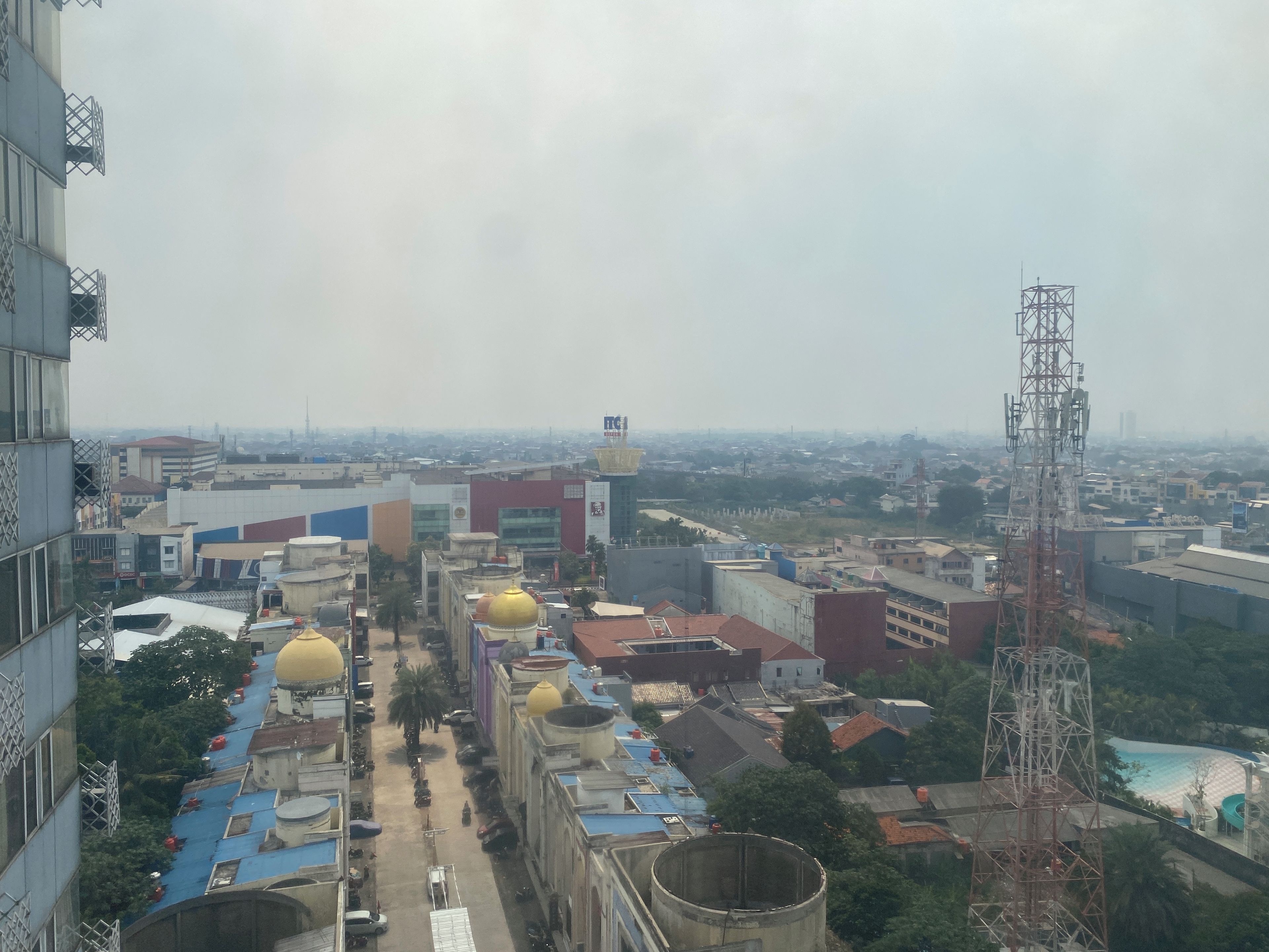 Paisagem urbana com diversos edifícios, incluindo uma torre imponente e uma estrutura em forma de cúpula.
