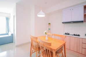 Cozinha moderna com mesa de jantar de madeira, cadeiras e luminária pendente.