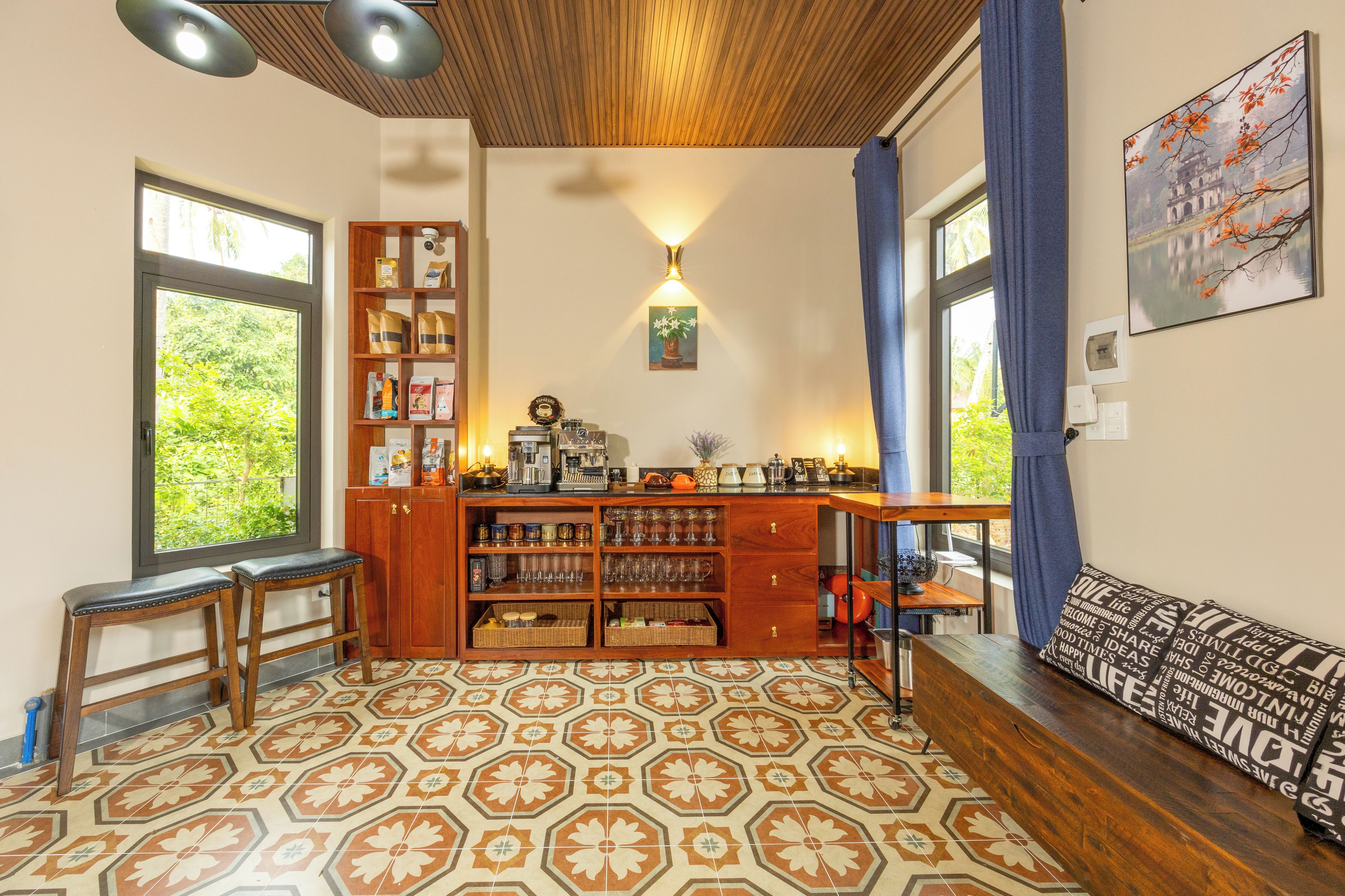 Quarto aconchegante com espaço para café, prateleiras com bolsas, piso estampado e vista pela janela.