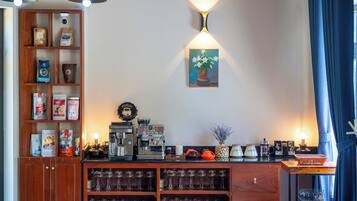 Café com máquina de café, máquina de expresso e diversos grãos de café e acessórios.