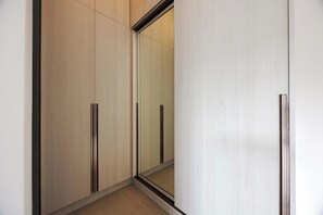 Corredor com painéis de madeira e parede espelhada.