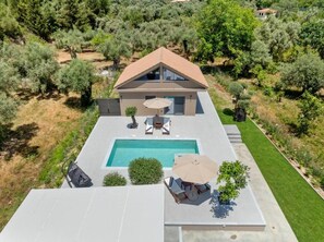 Uma casa moderna com piscina, área de estar ao ar livre e um jardim bem cuidado.