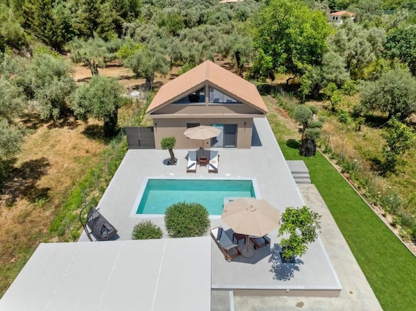 Uma casa moderna com piscina, área de estar ao ar livre e um jardim bem cuidado.