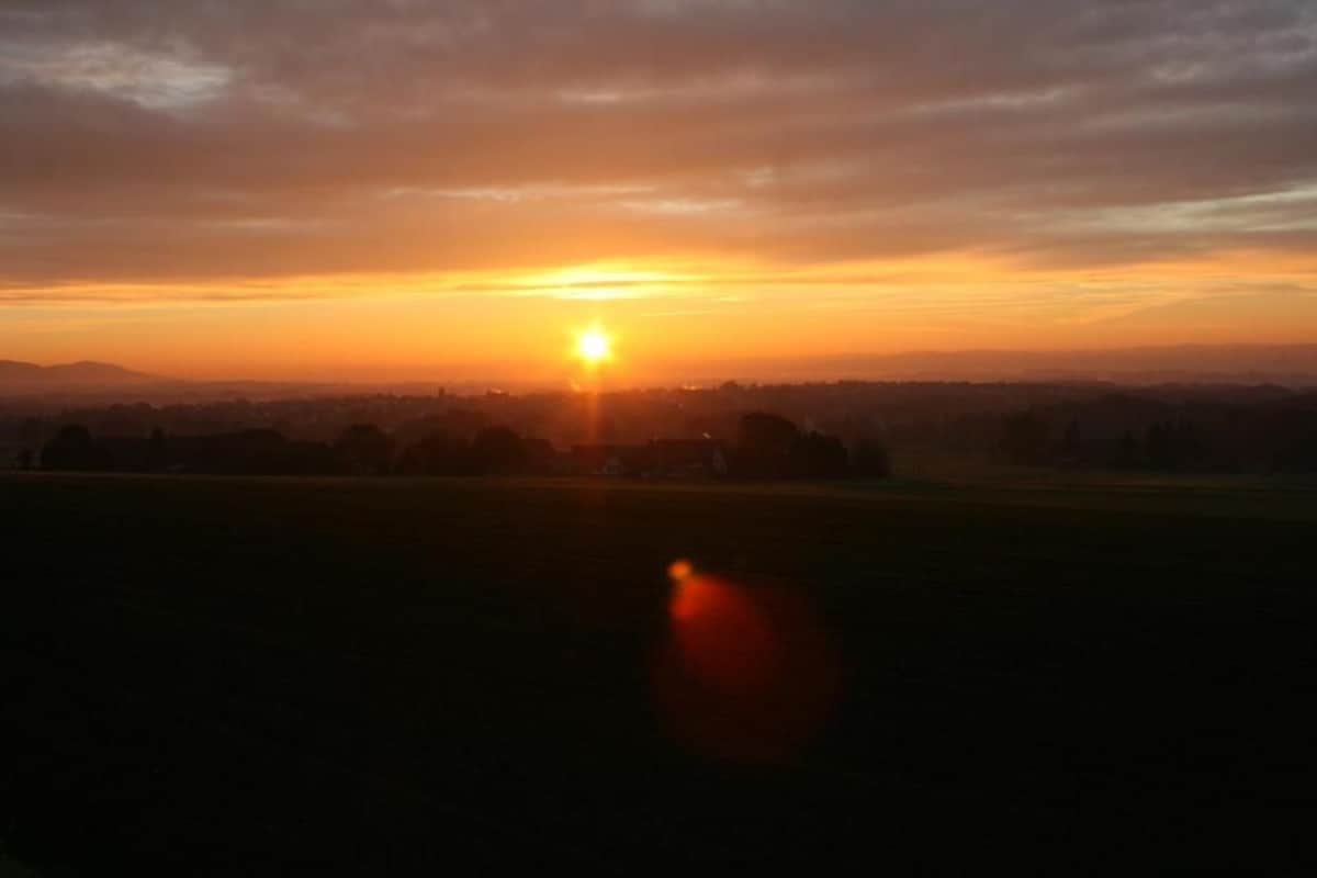 Pôr do sol sobre uma paisagem plana, com um único sol visível.