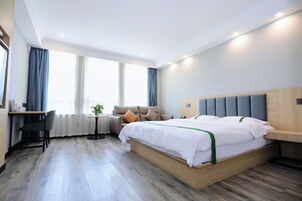 Quarto de hotel moderno com uma cama grande, uma mesa e uma cadeira.
